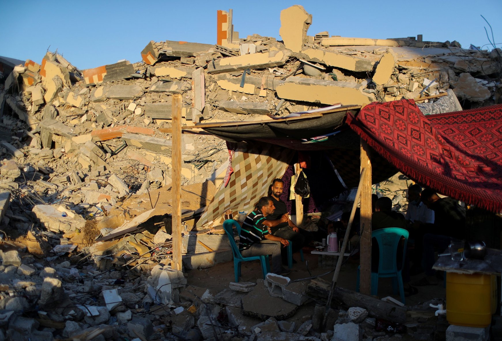 Palestinians in Gaza camp near rubble that used to be their homes ...